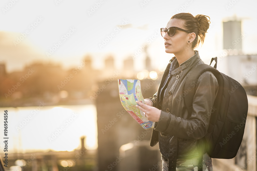 Confused female tourist in a foreign city using a map, trying to ...