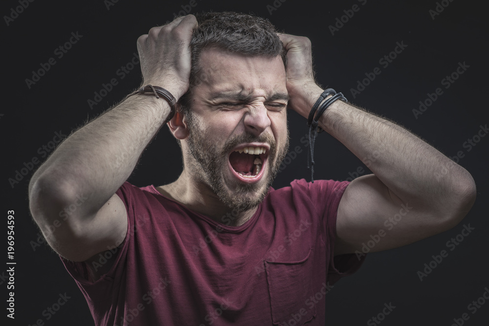 Enraged furious young man screaming in anger, pulling his hair out foto ...