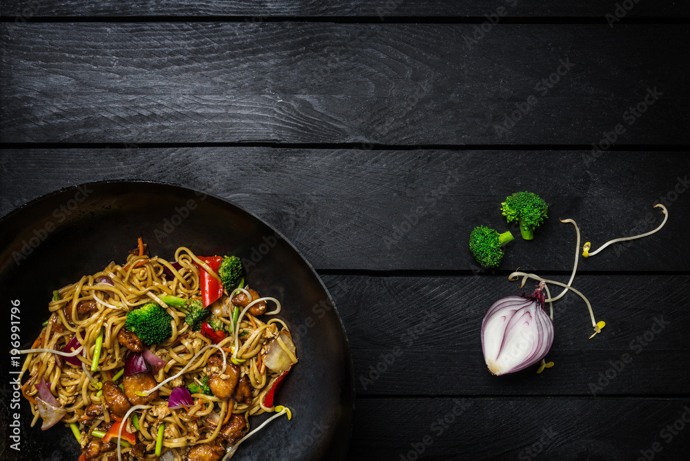 Stir fry noodles in traditional Chinese wok with ingredients. Space for ...