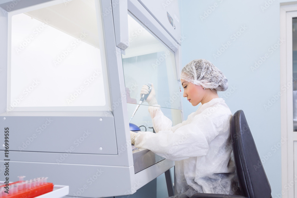 Close-up of female technician with multipipette and in genetic ...