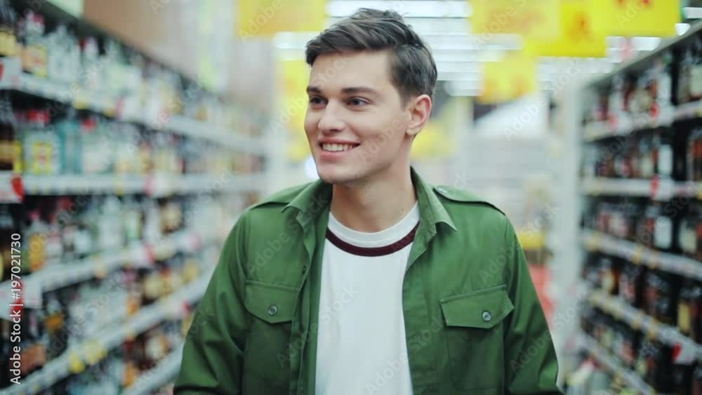 Close up smiling man walk with shopping cart at the supermarket feel ...