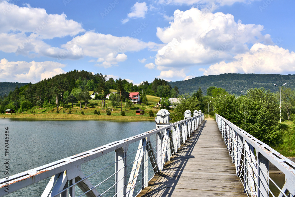 Pedestrian bridge over small dam on the Wisloka River in Krempna, Low ...