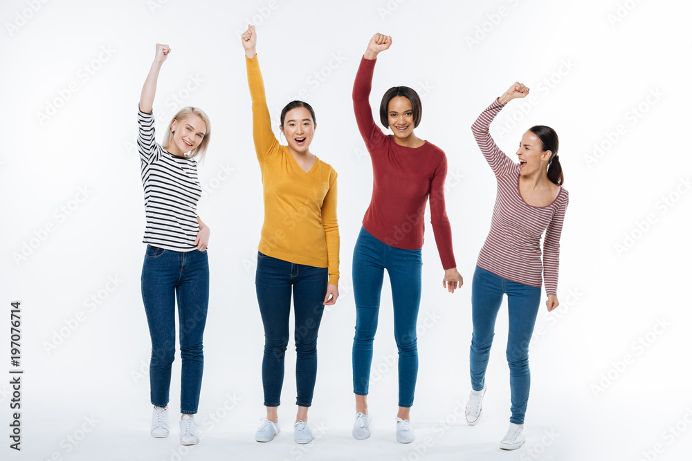 Our achievement. Joyful nice attractive women standing together and ...