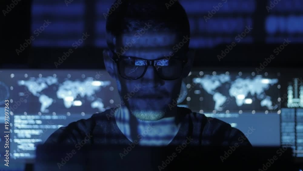 Vidéo Stock Hacker programmer in glasses is working on computer while blue binary code ...