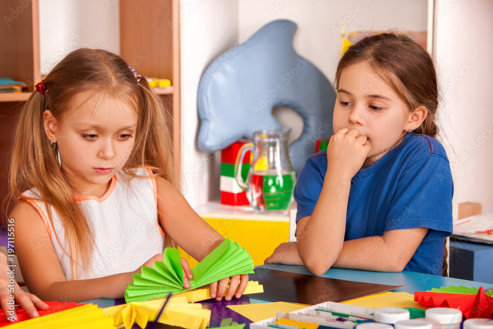 School children with scissors in kids hands cutting paper with teacher ...