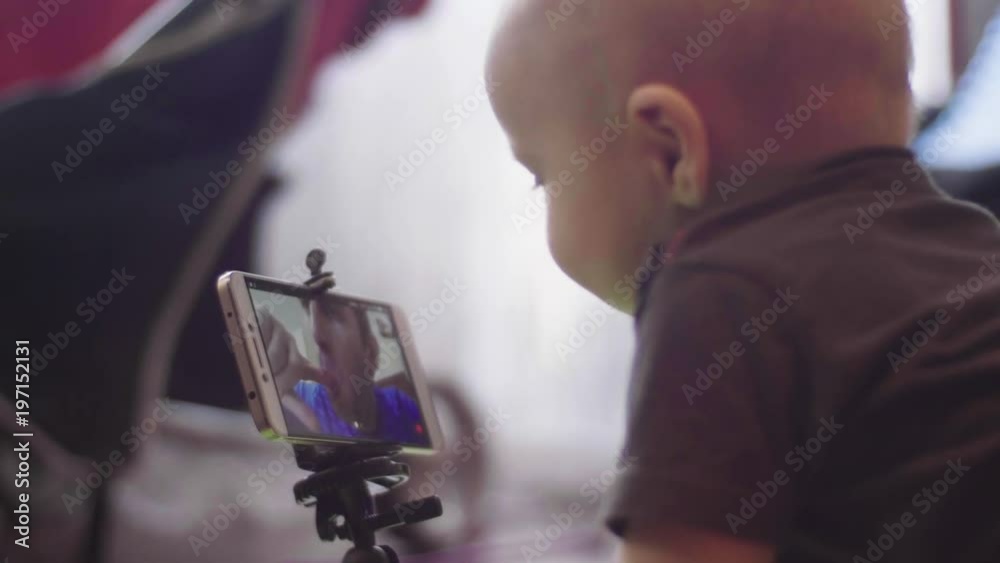 Vidéo Stock Small baby sitting on the floor communicates on video call ...