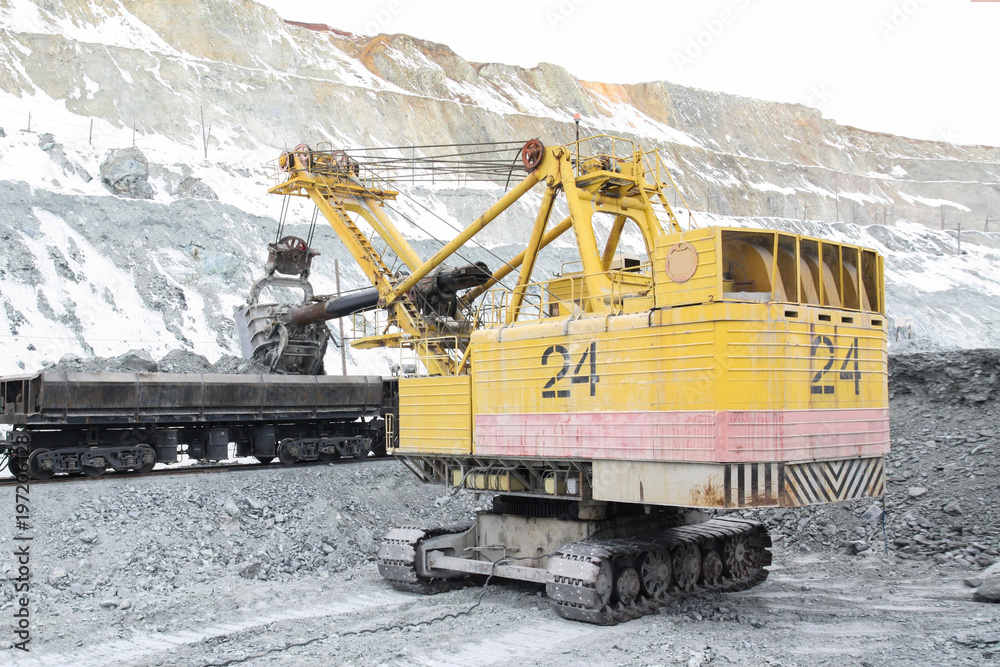 The excavator loads the stones into the cars. Loading ore into the ...