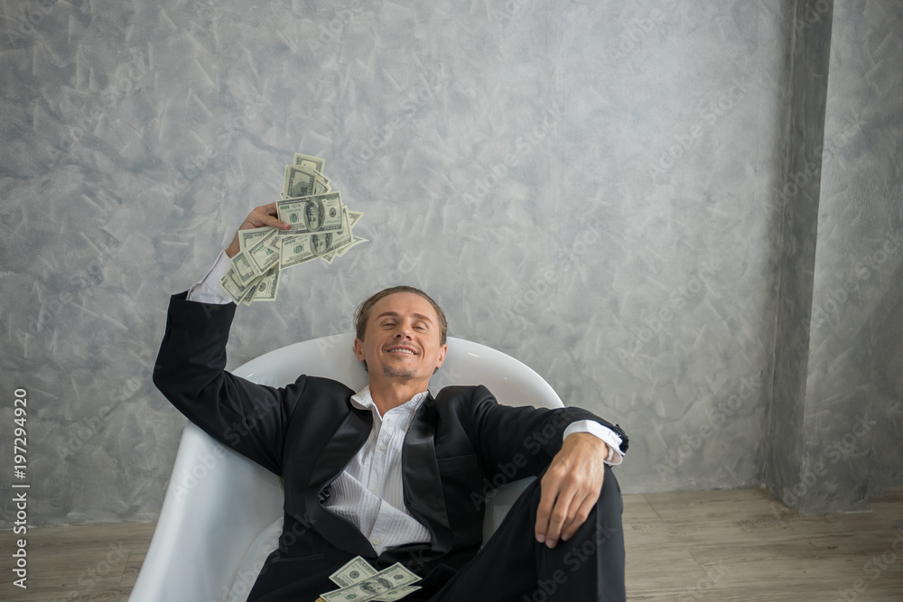 Rich businessman lying in bathtub filled with dollar banknotes. Success ...