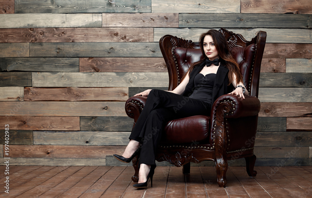 Portrait of a stunning fashionable model sitting in a chair in Art ...