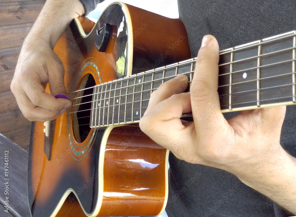 Acoustic guitar. A man plays an acoustic guitar with two hands close-up ...