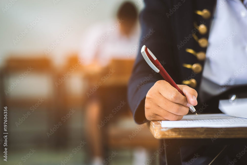Students writing and reading exam answer sheets exercises in classroom ...