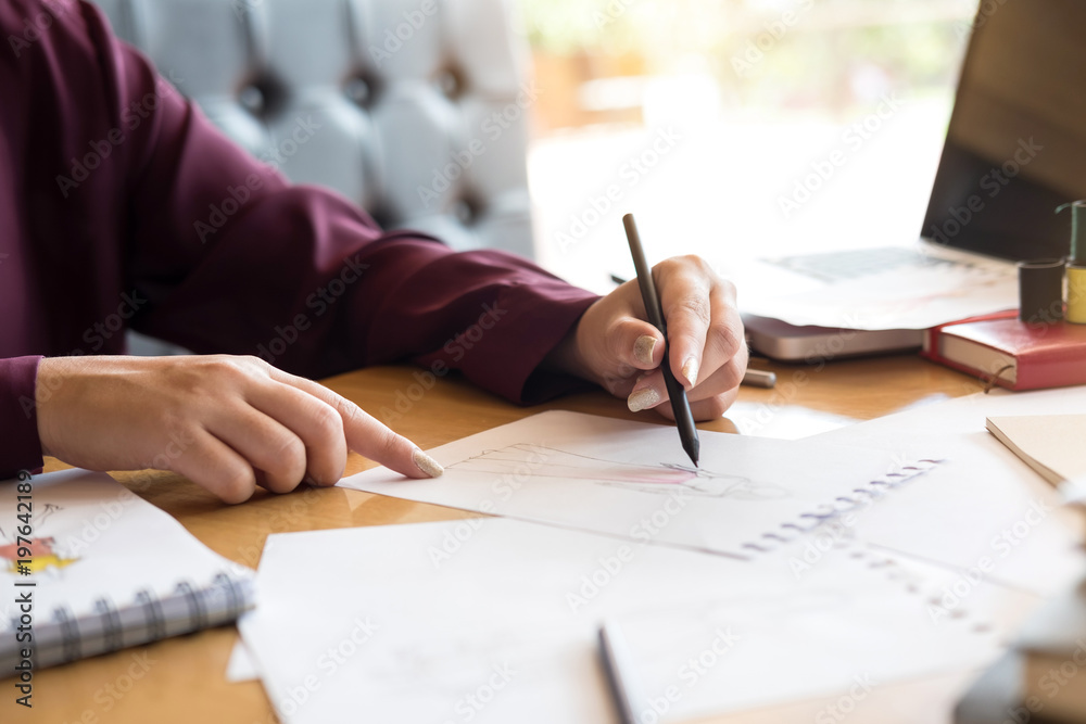 Close up of professional Fashion designer working and drawing sketches ...
