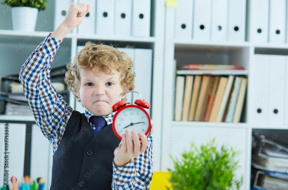 Angry boy trying to punch an alarm clock, standing in office. Lack of ...