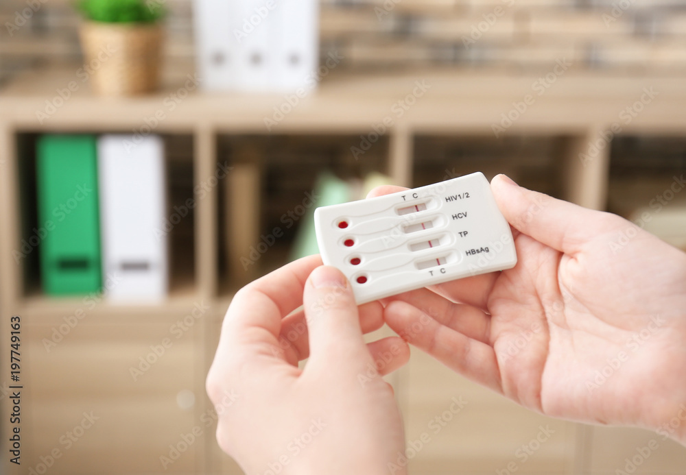 Woman holding test for HIV, Hepatitis B, C and Syphilis on blurred ...