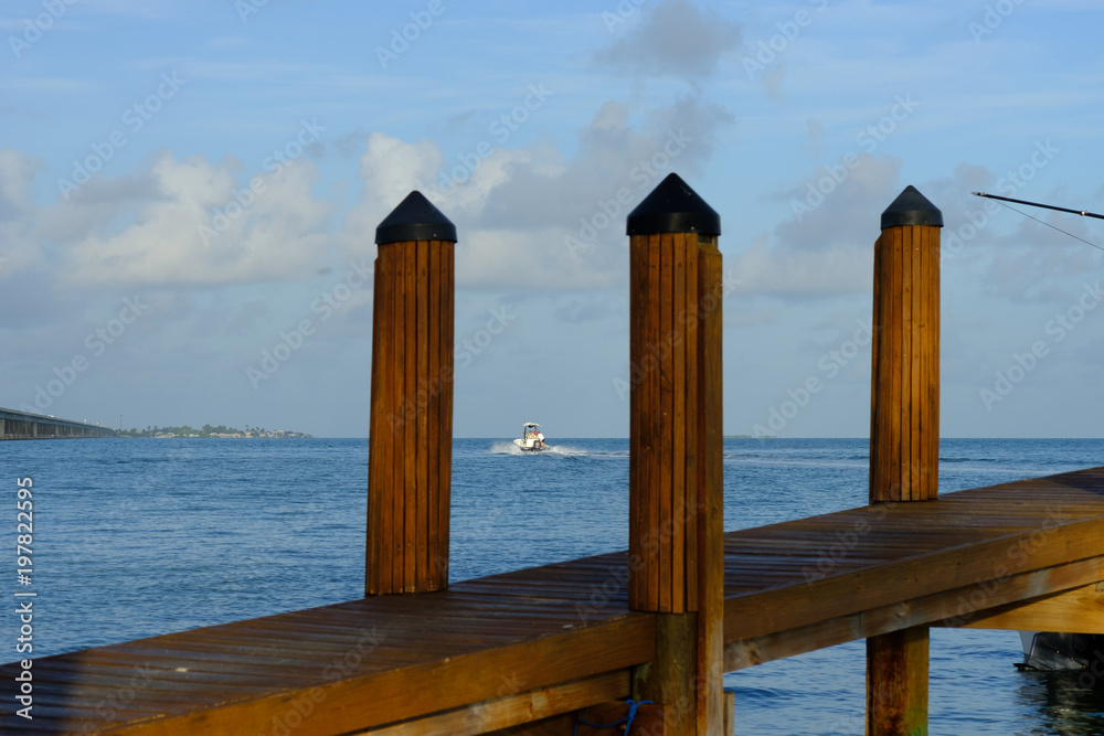 Small fishing motorboat heads out for an evening of fishing from a dock ...