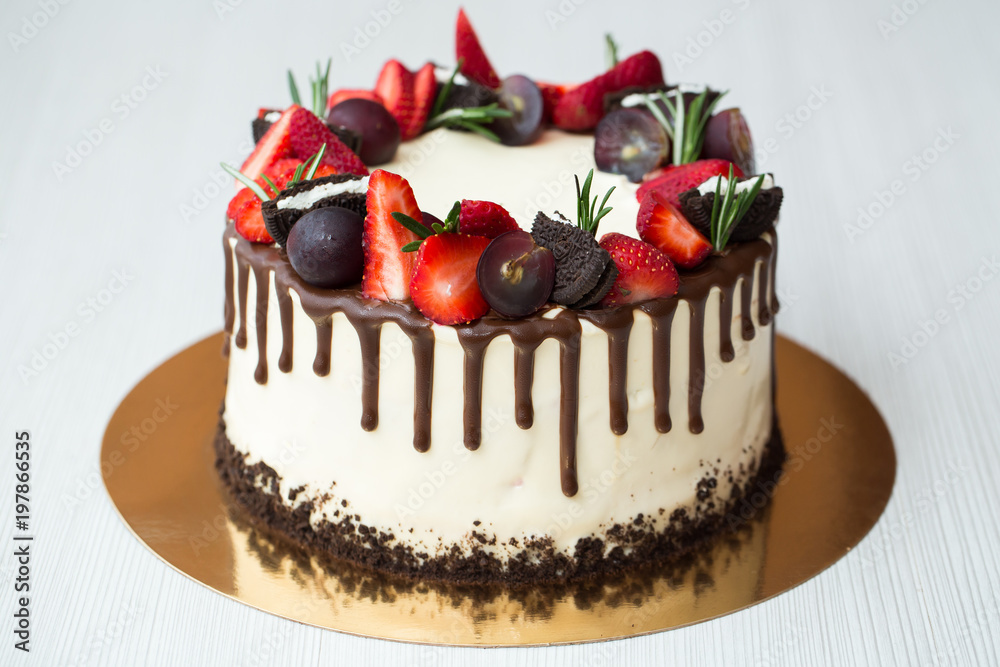 Cake with chocolate stains, strawberries, grapes, rosemary and Oreo ...
