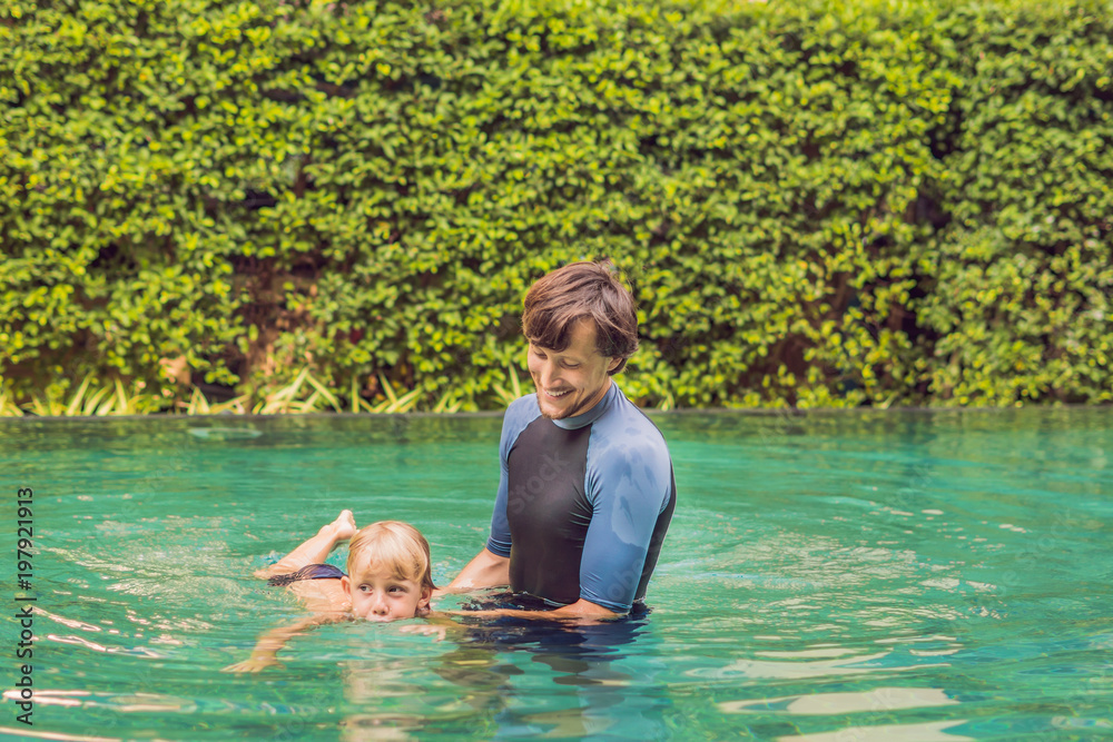 Male instructor swimming for children teaches a happy boy to swim in ...