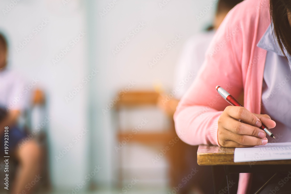 Students writing and reading exam answer sheets exercises in classroom ...