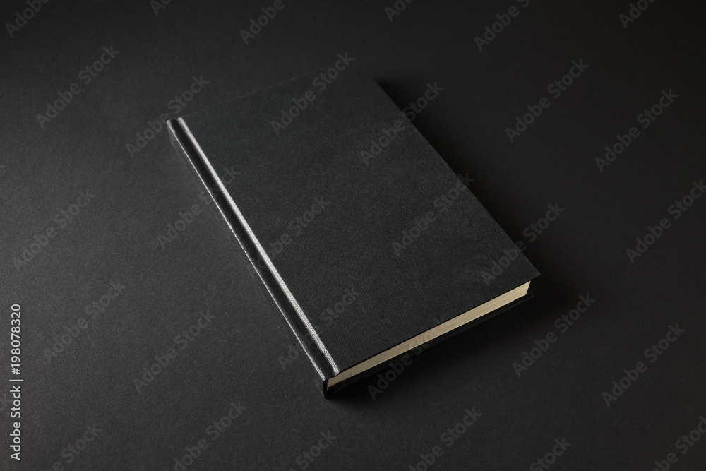 Blank black book cover on black paper background. Stock Photo | Adobe Stock
