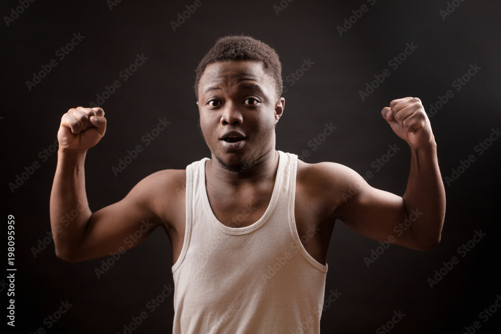 brutal man with dark skin with surprised look bending his elbows.being ...