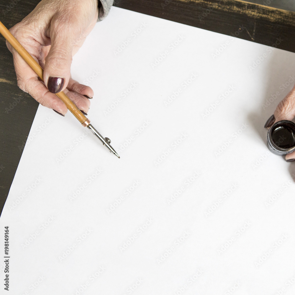 Woman create a calligraphy design work using drawing pen and ink ...