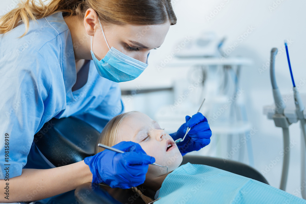 Nice service. Cute petite girl lying in a dentist chair with her eyes ...