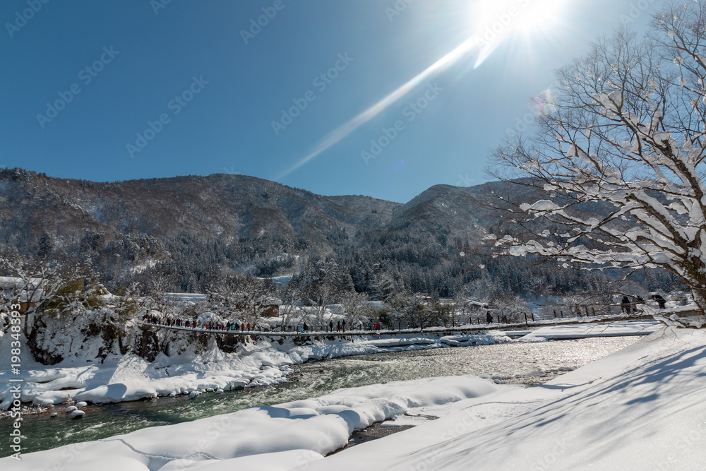 Tourists crossing the Deai-bashi suspension bridge to the village in ...