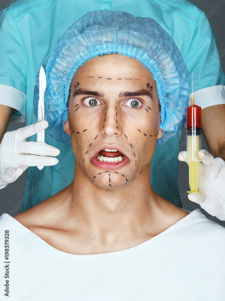 Man patient with open mouth in horror. Nurse with syringe and scalpel ...
