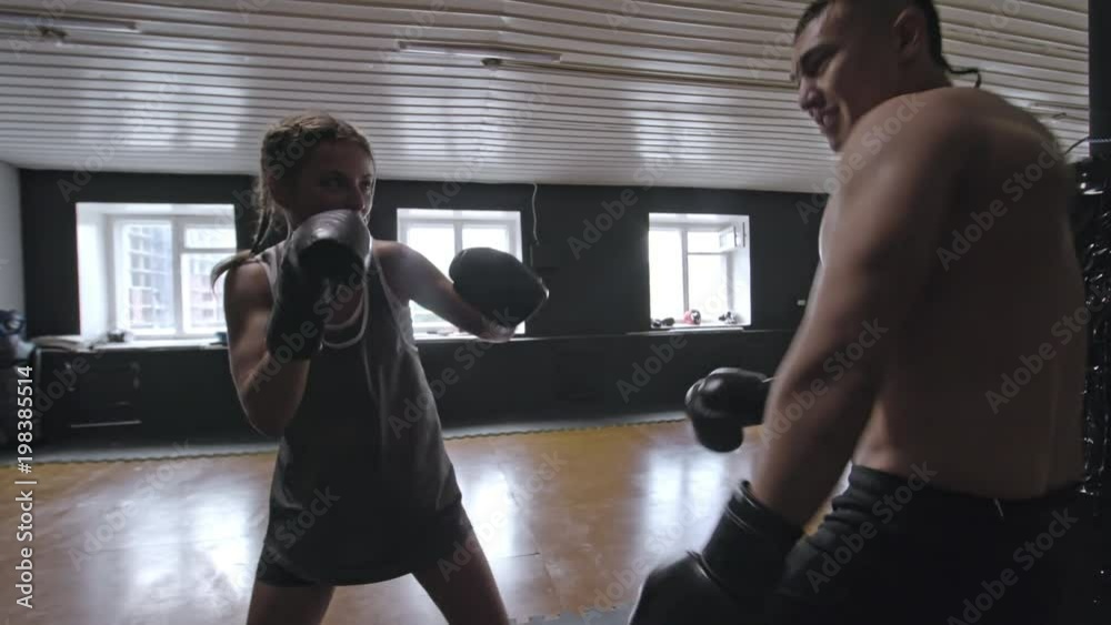 Shirtless young man with small braid dodging punches of his female ...