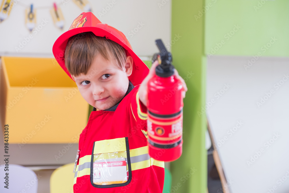 Foto de Caucasian boy kid dress up to fireman and use speaker at roll ...
