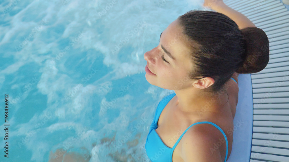 Beautiful young girl (woman) relaxed in a spa, in a blue bathing suit ...