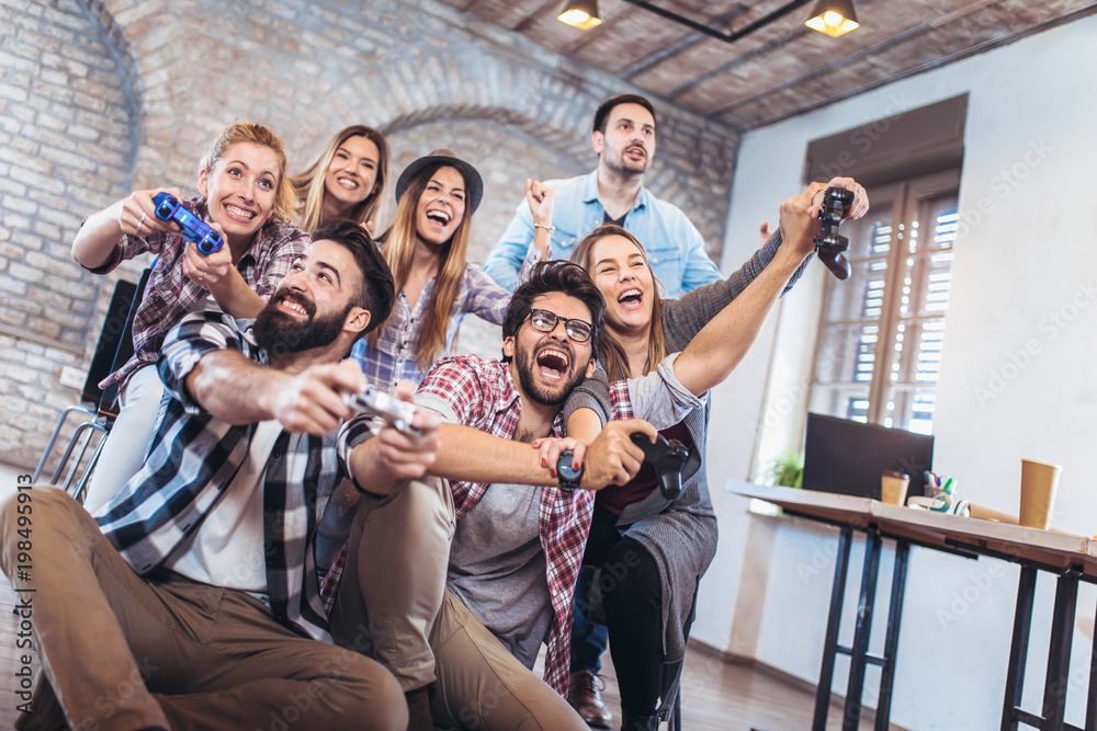 Coworkers playing video games in office. Stock Photo | Adobe Stock