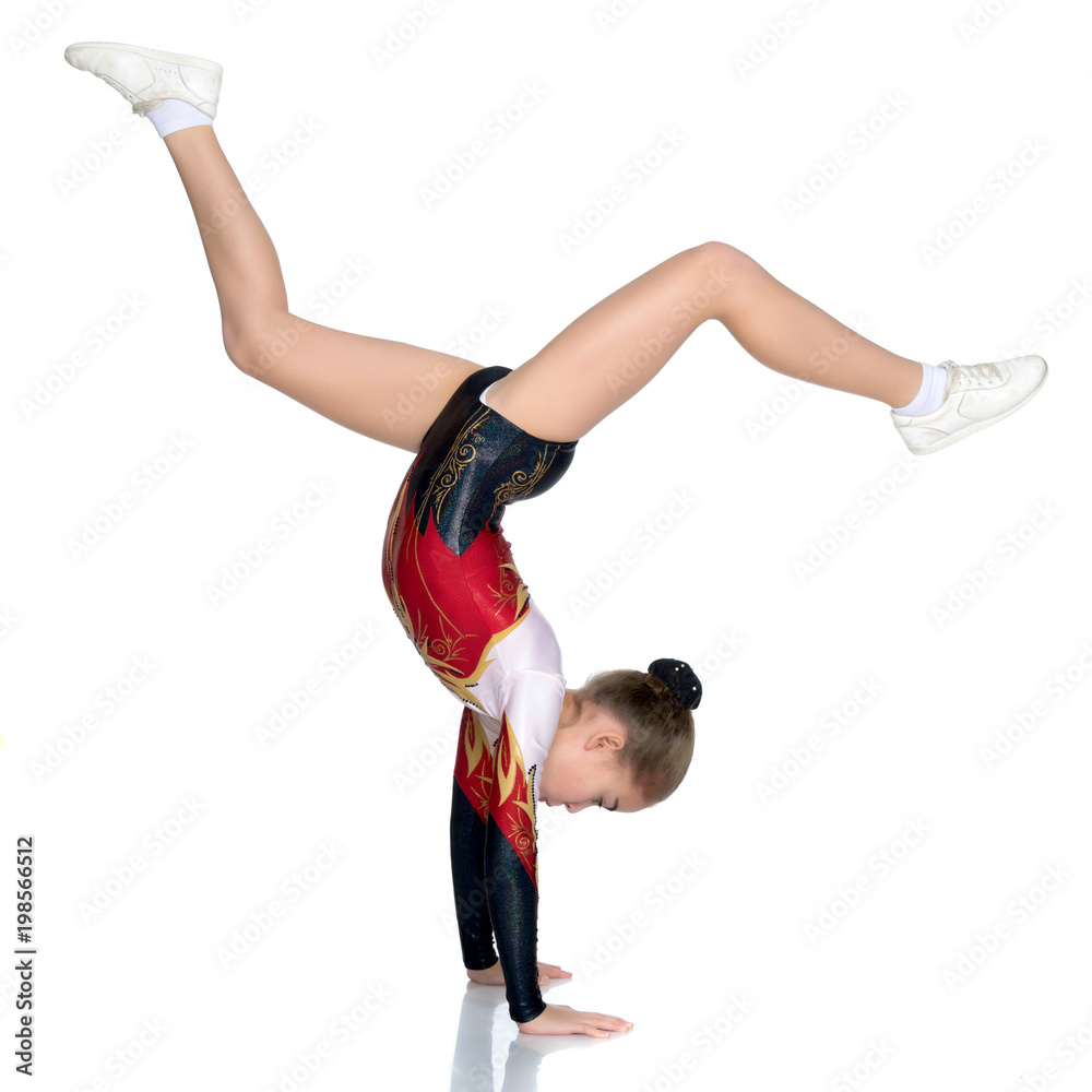 The gymnast performs a handstand with bent legs. Stock Photo | Adobe Stock