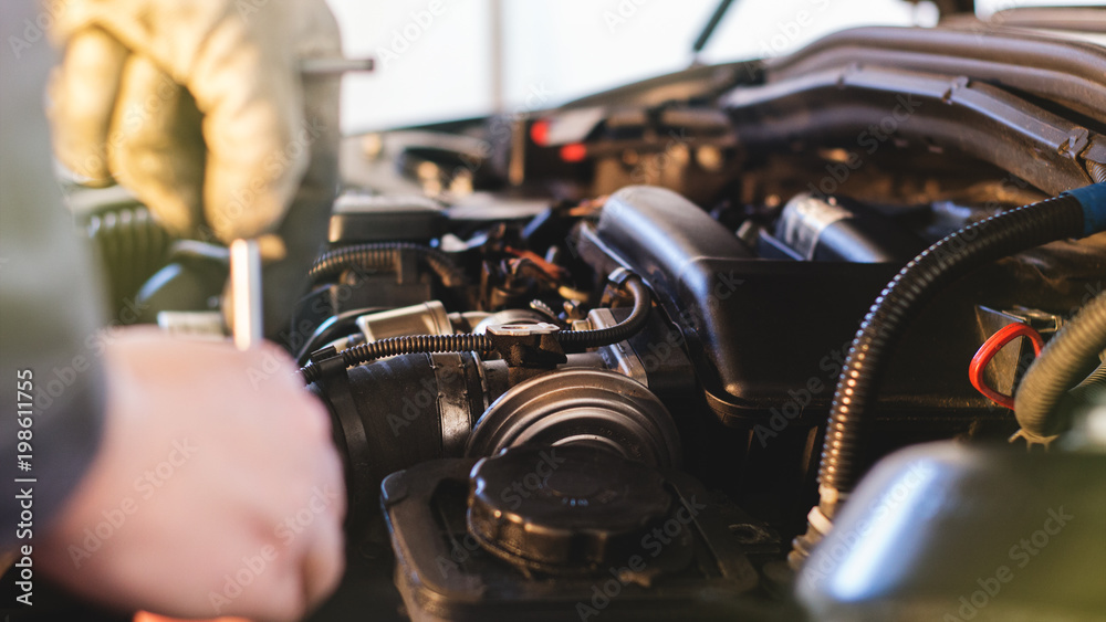 Mechanic unscrews the engine Stock-Foto | Adobe Stock