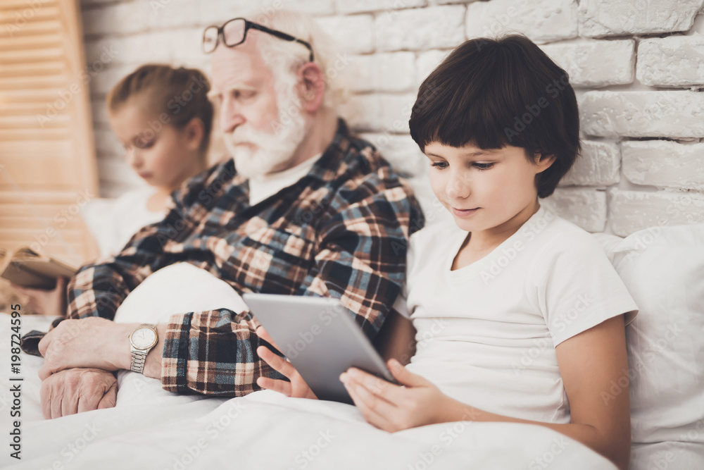 Grandfather, grandson and granddaughter at home. Grandpa is sleeping ...