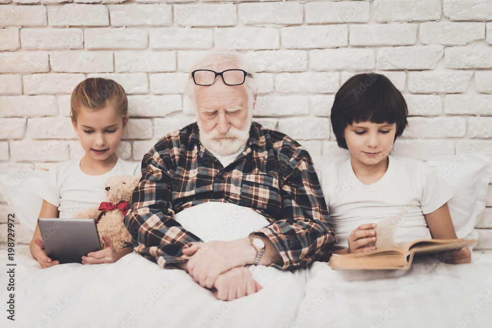 Grandfather, grandson and granddaughter at home. Grandpa is sleeping ...