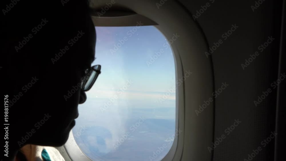 4k, Asian passenger look out of airplane window during plane flight ...