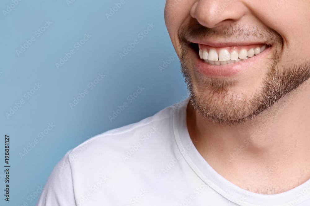 Young man with beautiful smile on grey background. Teeth whitening ...