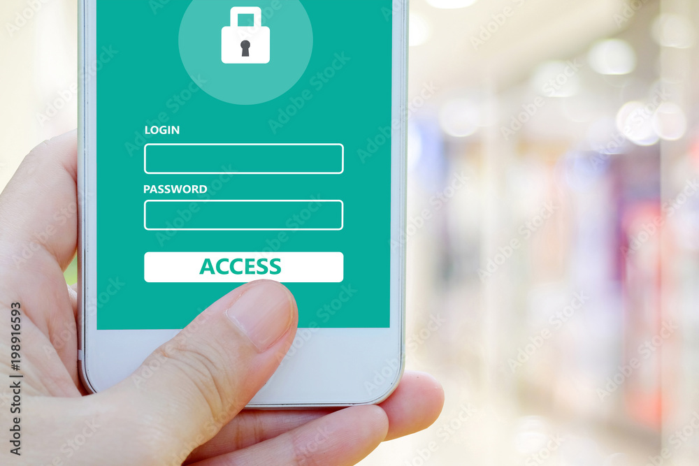 Hand using smart phone with password login on screen over blur ...