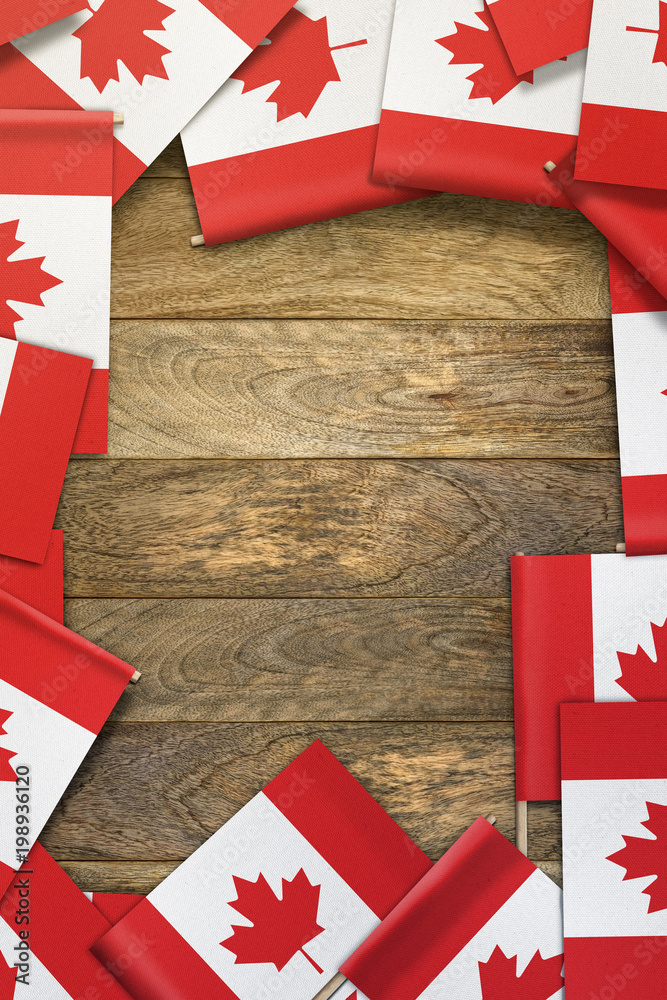 Canada small flags framing a wood texture background with copy space ...