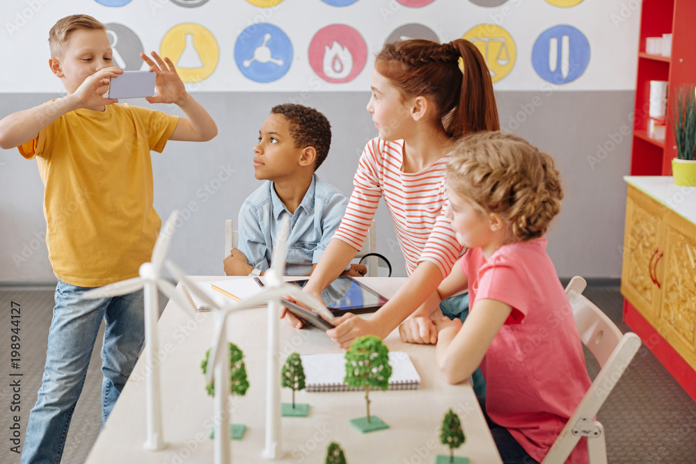 Saving precious memories. Charming teenage boy taking a picture of his ...
