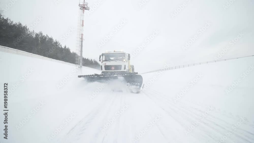 Snow and ice removal truck removes snow from the road with big bucket ...
