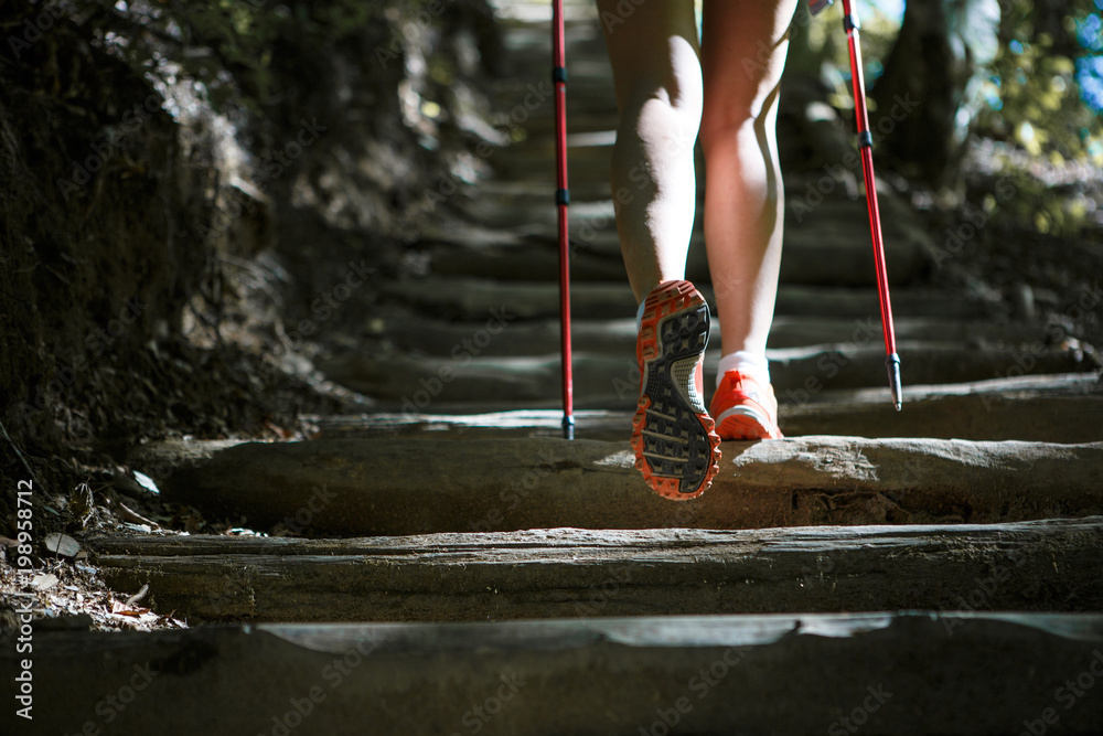 Foto de Female athletes with sticks for walking on ladder of logs do ...