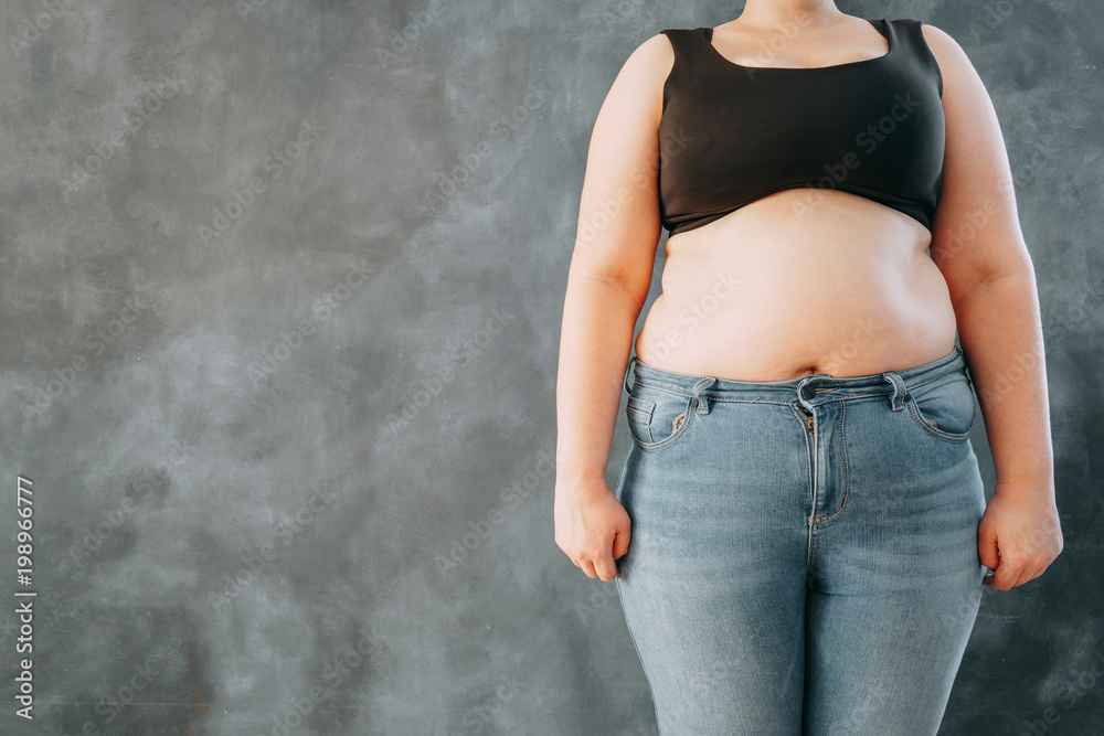 Unrecognizable overweight woman with obese body over studio background ...