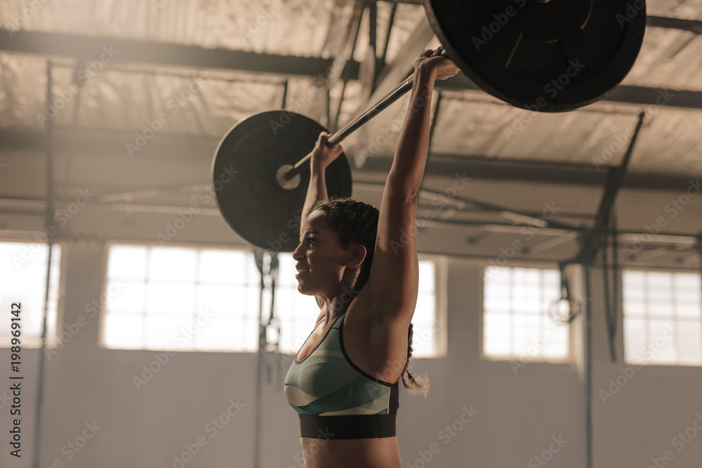 Female athlete lifting heavy weights Stock Photo | Adobe Stock