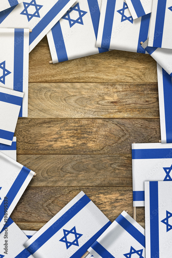 small Israel flags framing a wood texture background with copy space ...