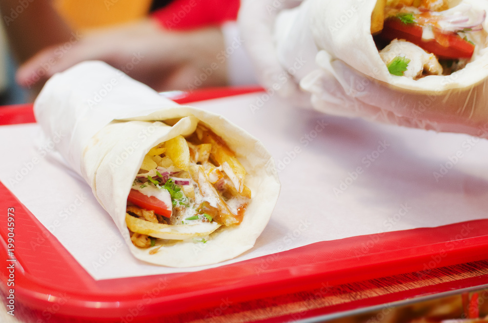 Shawarma meat chicken roll in a pita with fresh vegetables. Stock Photo ...