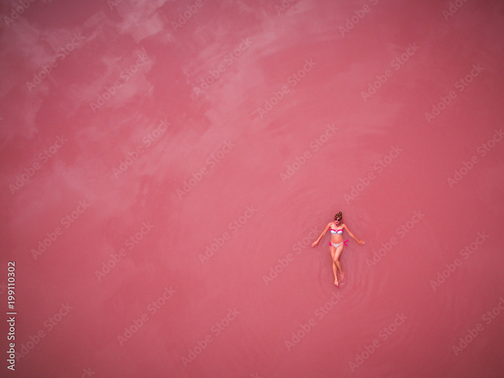 Pink lake, top view. beautiful girl in swimsuit lies on the water of ...