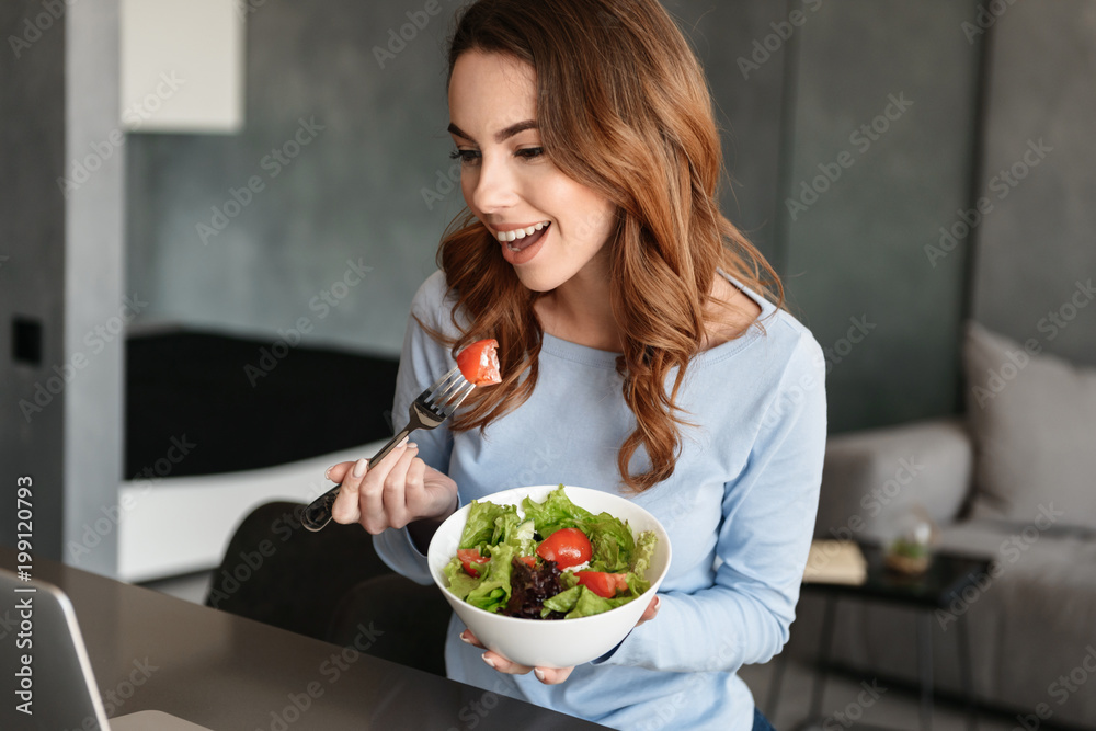 Portrait of a happy young woman eating Stock Photo | Adobe Stock