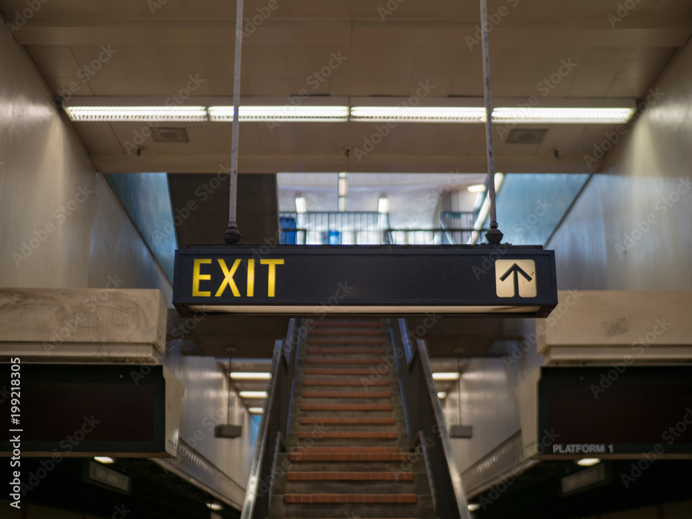 Exit sign in a dark tunnel with stairs leading up Stock Photo | Adobe Stock